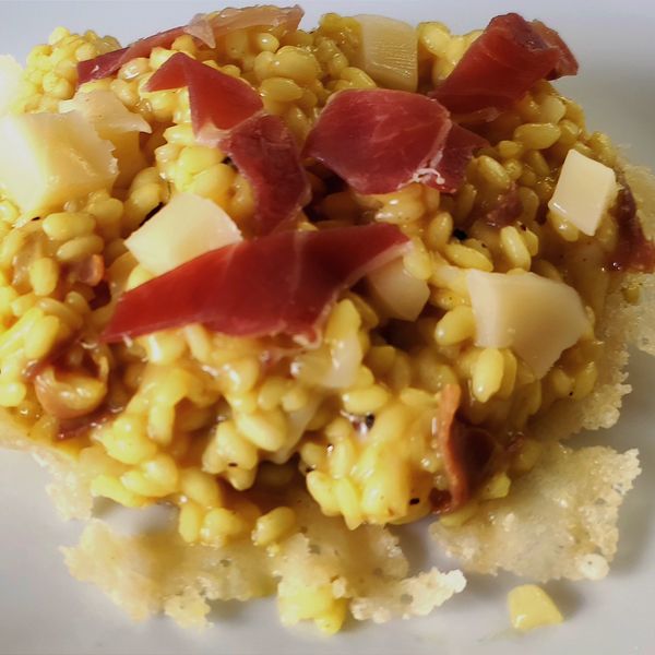 Risotto con prosciutto crudo, provola e curry su disco di parmigiano ...